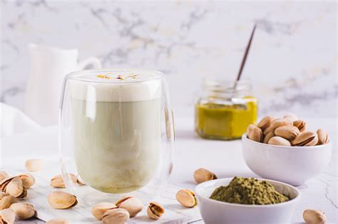 피스타치오를 곁들인 말차와 테이블 위의 견과류를 유리잔에 담아 가루로 빻은에 대한 스톡 사진 및 기타 이미지 가루로 빻은 피스타치오 0명 Istock