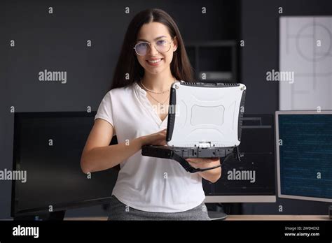 Pretty Young Female Programmer With Old Laptop Working In Office Stock