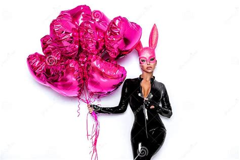 Blonde Woman Posing In Latex Black Costume And Pink Bunny Mask And Pink