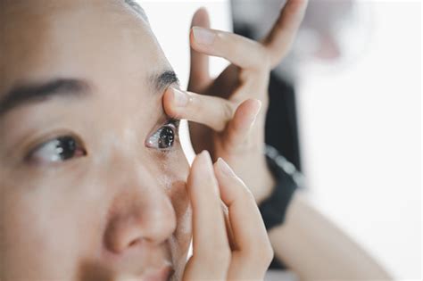 시각을 위한 콘택트 렌즈 그녀의 눈에 콘택트 렌즈를 바르는 여성 얼굴의 근접 촬영 손으로 눈 렌즈를 넣는 아름다운 여성 안과