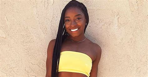 Simone Biles Shows Off Athletic Figure Posing In Yellow Tube Top And High Waisted Jeans