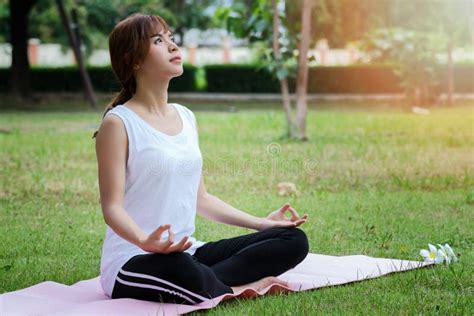 Young Asian Woman In Sportswear Meditating While Sitting In Lotus Pose
