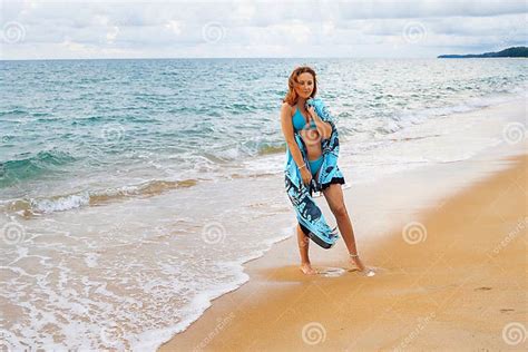 A Beautiful Girl In A Bikini On A Wild Beach Bathing In The Clear Waves Of The Warm Sea A