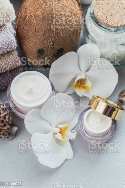 코코넛 오일 바다 소금 수건 및 회색 배경에 흰색 오키드 꽃이있는 수제 비누를 가진 유기농 화장품 보습제에 대한 스톡 사진 및