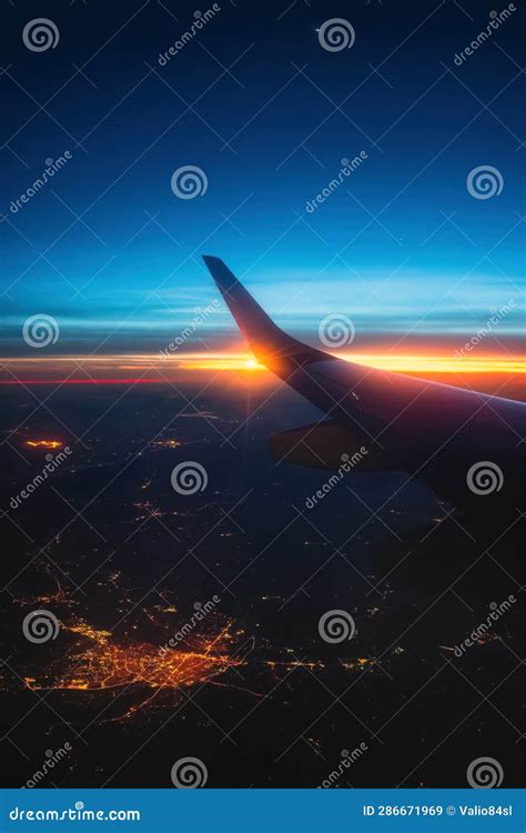Airplane Flight In Sunset Sky Over Earth Of City Light And Wing Of