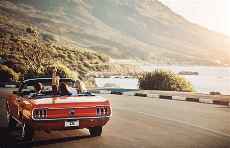 시골 휴가나 휴가를 위해 일몰까지 도로 여행을 위한 여행 자유 및 차에 있는 사람들 모험 자연 그리고 주말 목적지로 운전하기 위한 컨버터블의 친구들 20 24세에 대한 스톡