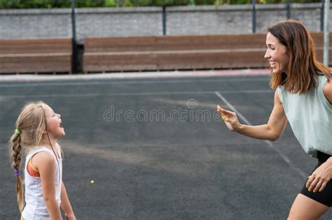 Mom And Daughter Have Fun On The Outdoor Sports Ground A Caucasian