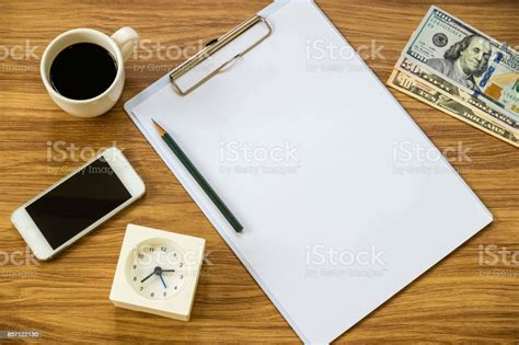 크리에이 티브 플랫 달러 현금 지폐 노트북 클립보드 스마트폰 시계 커피 나무 테이블에 연필 비즈니스 재무 계획 및 저장 개념의