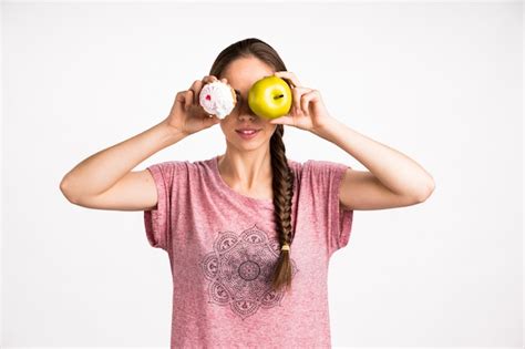 Mujer Que Cubre Su Rostro Con Cupcake Y Manzana Foto Gratis