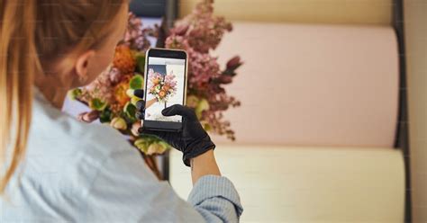 니트릴 장갑을 낀 금발 여성이 스마트폰을 사용하여 꽃다발 사진을 찍고 있다 사진 Unsplash의 사진 메시지 이미지