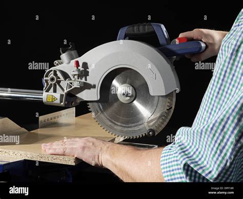 Carpenter Cutting Flaxboard Using Sliding Compound Mitre Saw Stock