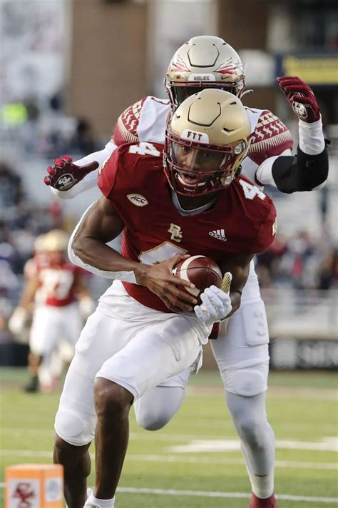 Two Football Players Are Running With The Ball