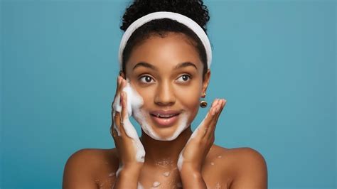 Headshot Of Pretty Dark Skinned Young Model Touches Cheek With Foam