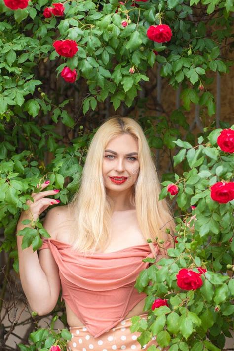 Beautiful Woman With Long Blonde Hair And Red Lips Wearing Pink Clothes