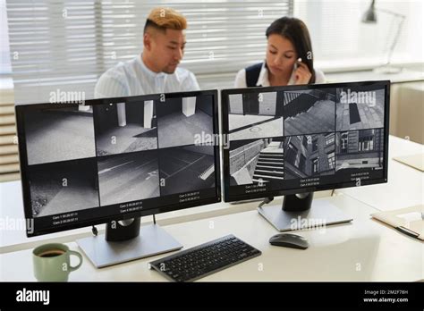 Background Image Of Two Computer Screens With Multiple Surveillance Camera Feeds In Monitoring