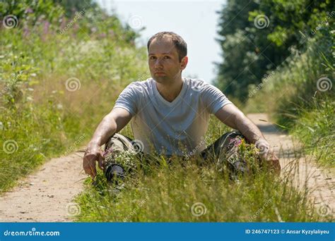 Un Type En Uniforme Militaire Est Assis Sur Le Sol Sur Le Fond Dune