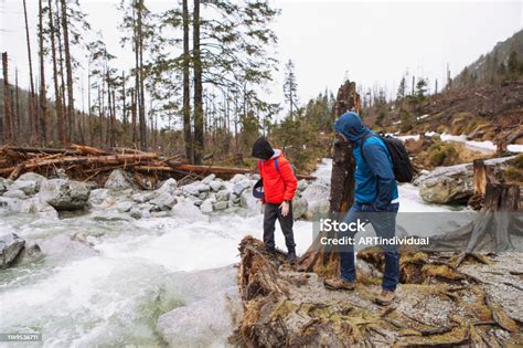 잘 생긴 아버지와 아들은 슬로바키아 하이 타트라 스의 비오는 날에는 하이킹 여행 중에 산 강둑에 서 서 이야기 하 고 있습니다