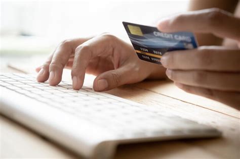 Premium Photo Cropped Hands Of Person Using Computer And Credit Card