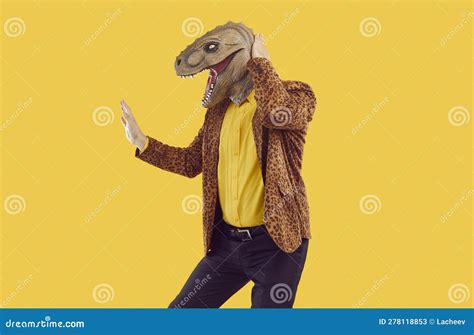 Cheerful And Eccentric Man With Dinosaur Head Dancing Isolated On Vivid