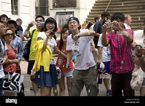 Young Japanese Tourists In The Financial District By The Ny Stock