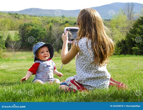 Flickan Som Tar Fotoet Av Behandla Som Ett Barn Arkivfoto Bild Av