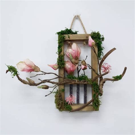 a wooden frame with flowers and branches hanging from it