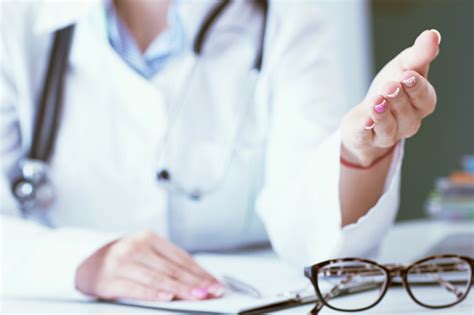 의사는 환영 제스처를 만들기 정중 하 게 의료 사무실 클로즈업에 앉아 환자를 초대 건강 진단에 대한 스톡 사진 및 기타 이미지 건강 진단 건강관리와 의술 계약서