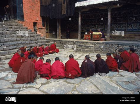 A Group Of Young Novice Monks Sitting In A Circle During An Oral