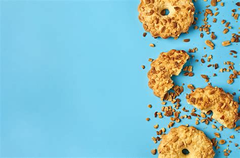 땅콩과 부스러기가있는 신선한 원 귀리 쿠키의 전체 및 반쪽은 부엌의 파란색 책상에 놓여 있습니다 텍스트의 공백입니다 맨 위 보기 건강한 식생활에 대한 스톡 사진 및 기타