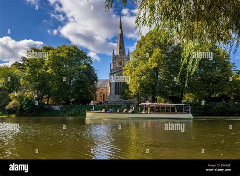 A River Cruise Boat Passing Holy Trinity Church At Stratford Upon Avon