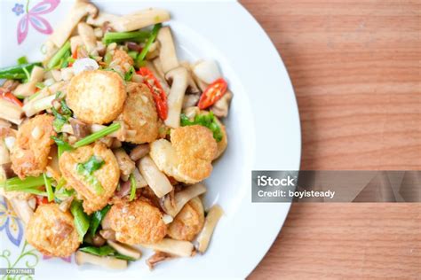 뜨거운 볶음 두부와 돼지고기 버섯과 검은 콩 소스를 곁들인 요리는 갈색 테이블에 놓인 흰색 접시에 얹어져 있습니다 수제 음식 컨셉 건강한 생활방식에 대한 스톡 사진 및 기타