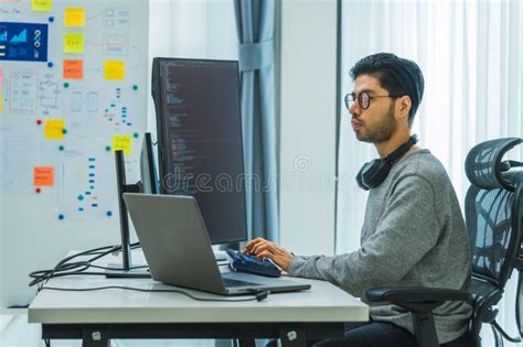 asian man prompt engineer develop coding app with software data sitting in front of computer