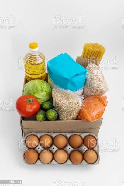 회색 배경에 고립 된 음식 기부 상자 양배추 오이 토마토 밀가루 해바라기 기름 스파게티 오트밀 렌즈콩 계란 상자에 0명에 대한