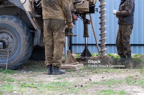 차에 드릴링 리그를 가진 노동자의 팀은 지상에 있는 물을 위한 지하수 우물을 뚫고 있습니다 금속 케이싱 파이프를 땅에 삽입 개별 식수 공급 장치 설치 2022년 6월 28일
