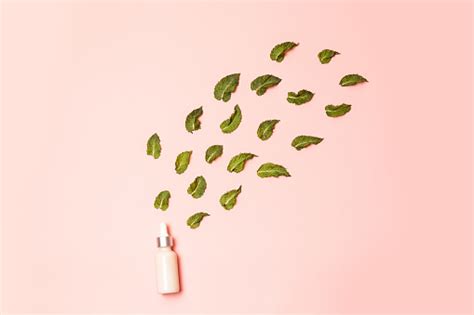 분홍색 배경에 민트 꽃잎이 있는 유리 튜브에 천연 에센셜 오일 세럼 액상 드롭퍼 플랫 레이 상단 보기 0명에 대한 스톡 사진 및