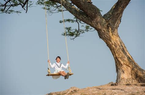 Premium Photo Girl Swinging Against Clear Sky