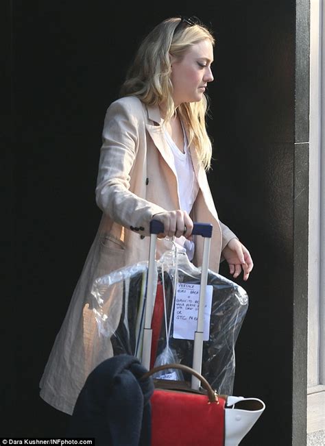 Dakota Fanning Wears Striking Winged Eyeliner While Dragging Luggage