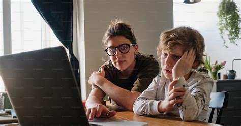 어린 소년은 노트북의 모니터를보고 생각하고 그는 테이블에서 교사와 함께 온라인으로 작업을 수행 사진 Unsplash의 가정 교사 이미지