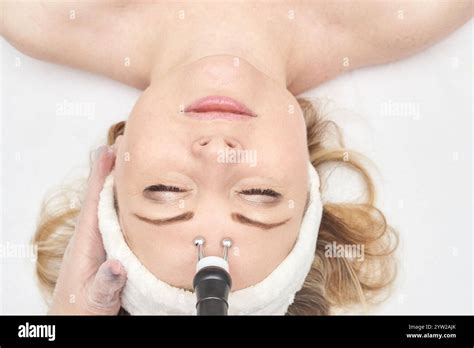 Female Caucasian Adult Receiving Facial Microcurrent Treatment In Spa