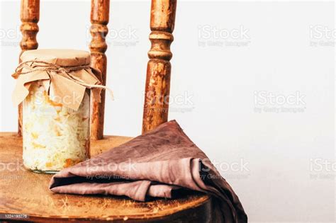 재활용 재료로 종이로 덮인 투명 유리 항아리에 발효 야채 양배추 흰색 배경에 나무 빈티지 배경에 건강한 식생활에 대한 스톡 사진