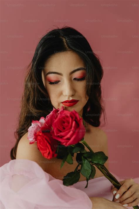 Foto Zum Thema Eine Frau In Einem Rosa Kleid Mit Einer Rose Bild Zu