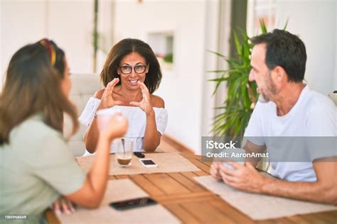 테라스에 앉아 커피 말하기와 미소의 컵을 마시는 아름다운 가족 가족에 대한 스톡 사진 및 기타 이미지 가족 남자 단체