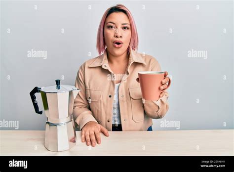 Hispanic Woman With Pink Hair Drinking A Cup Of Italian Coffee Scared