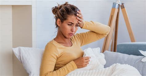 담요 아래에 앉아 두통을 가진 아픈 여자 계절성 감염 독감 알레르기가있는 아픈 여자가 침대에 누워 있습니다 아픈 여자는 고열과 독감으로 침대에 누워 담요로 덮여