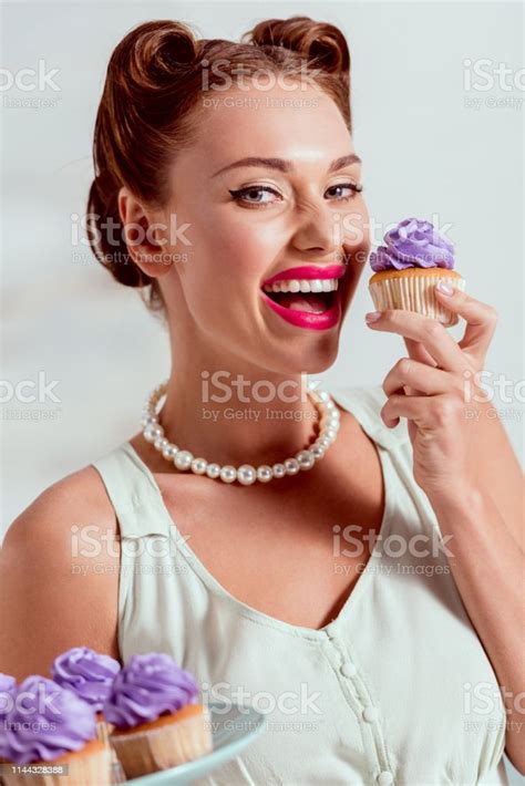 Smiling Pin Up Girl Going To Taste Homemade Cupcake With Purple Cream