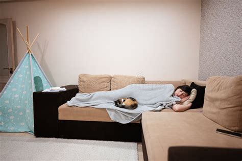 Joven Tendida Y Dormida En La Cama Con Su Gato Imagen De Archivo