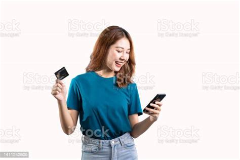 하얀 배경에 고립 된 신용 카드와 스마트 폰 몸짓을 들고있는 귀여운 아시아 여성 신용 카드에 대한 스톡 사진 및 기타 이미지