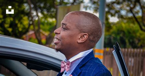 차 옆에 서 있는 파란 양복을 입은 남자 사진 Unsplash의 무료 의류 이미지