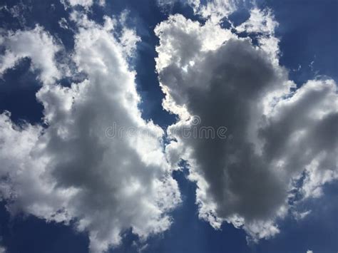 White And Dark Clouds With Sun Shining Behind Clouds Stock Image