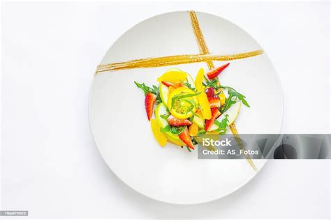 열대 과일 꽃의 다양한 종류와 큰 접시 채식주의자 채식주의자 및 생 식도자를 위한 음식 흰색 접시에는 오렌지 아루굴라 사과 딸기